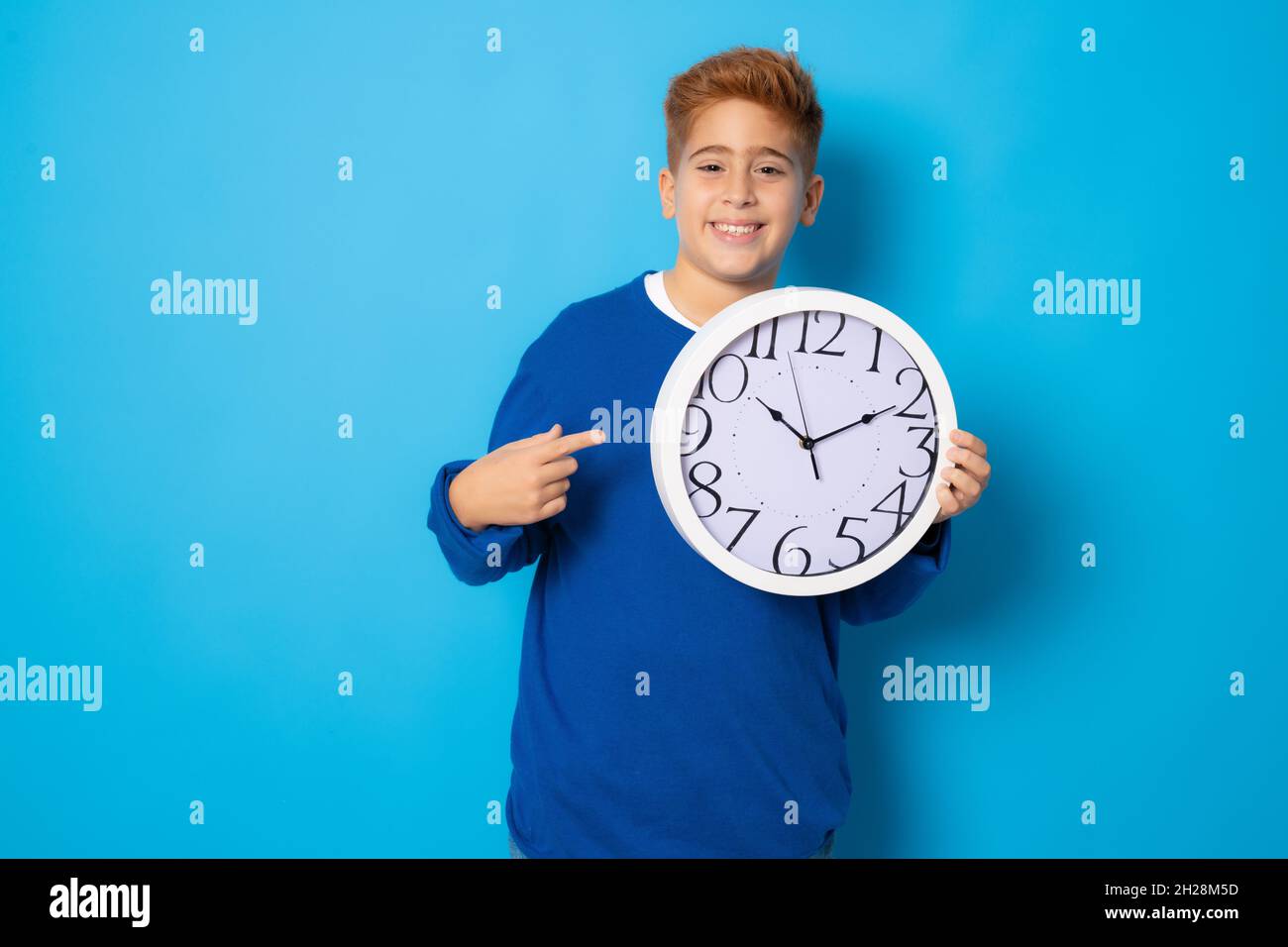 Portrait of caucasian boy with clock. Education and time concept Stock ...