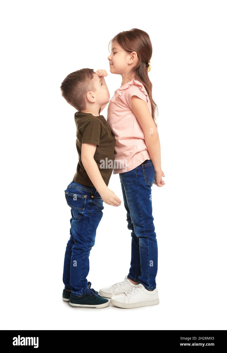 Little children measuring and comparing their height on white ...