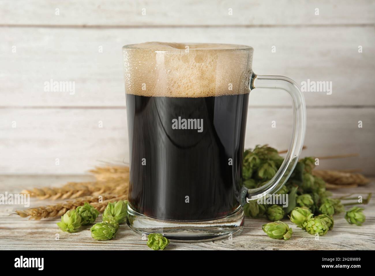 Composition with tasty beer, wheat spikes and fresh green hops on ...