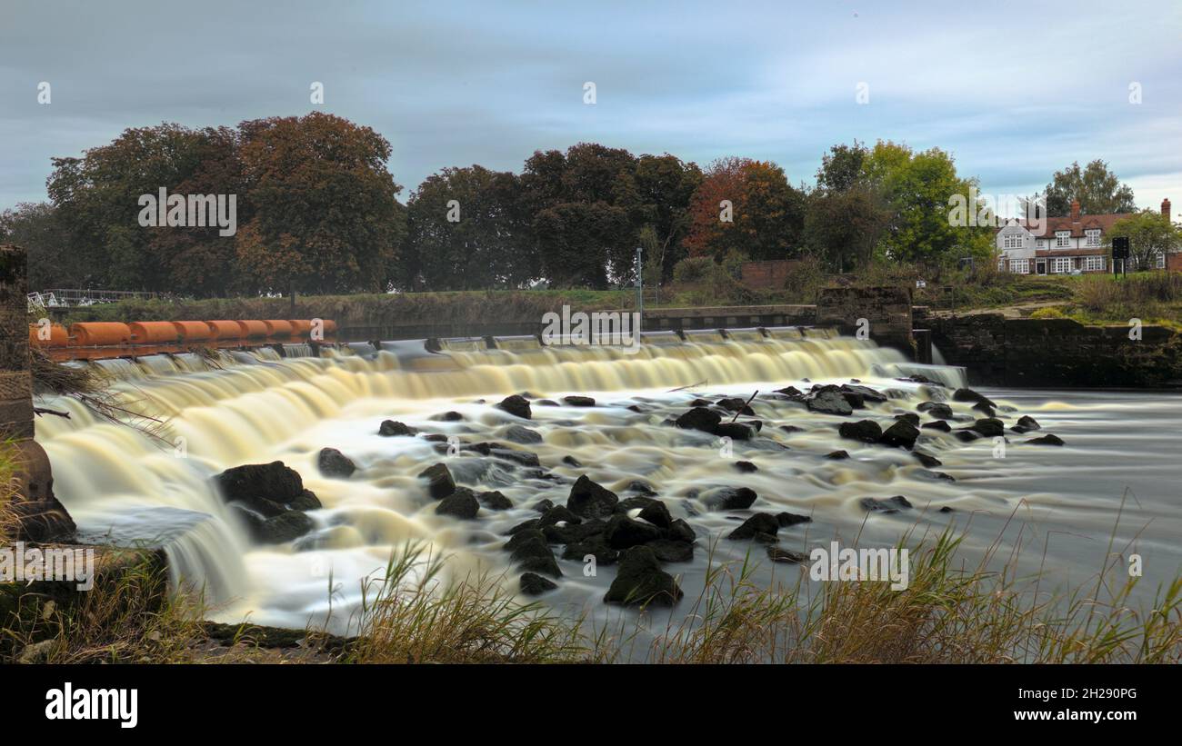 Weir at Naburn Locks on the River Ouse with the lock keeper cottage ...