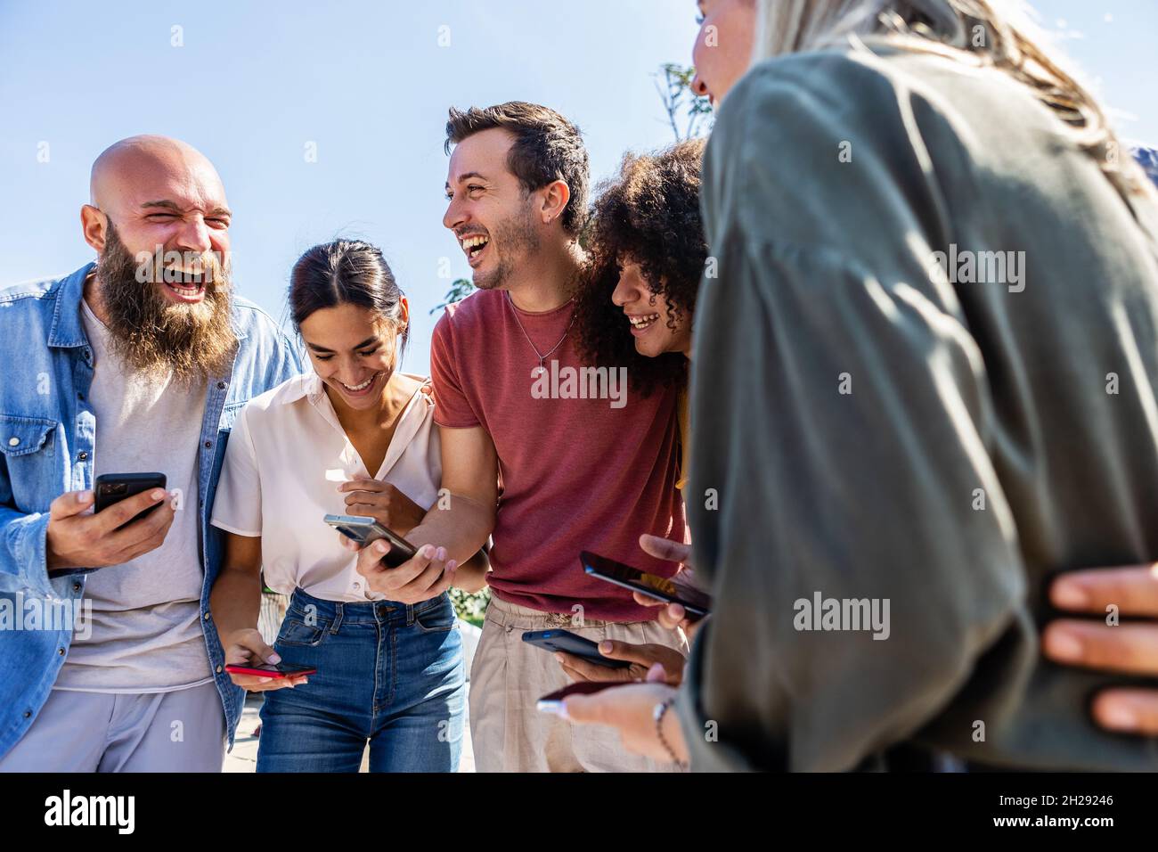 Friends laughing mobile device watching hi-res stock photography and ...