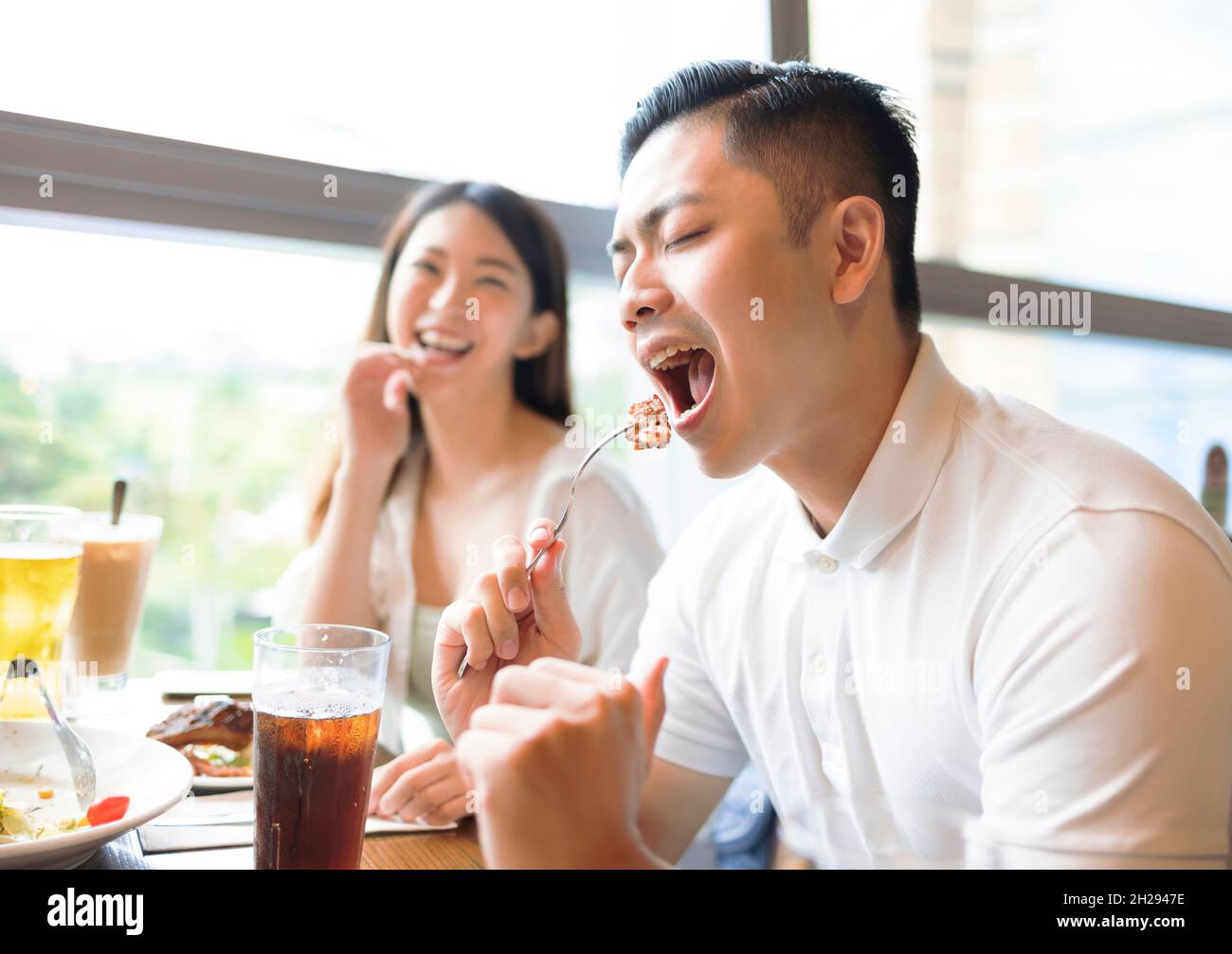 Happy couple having fun during lunch in restaurant Stock Photo - Alamy