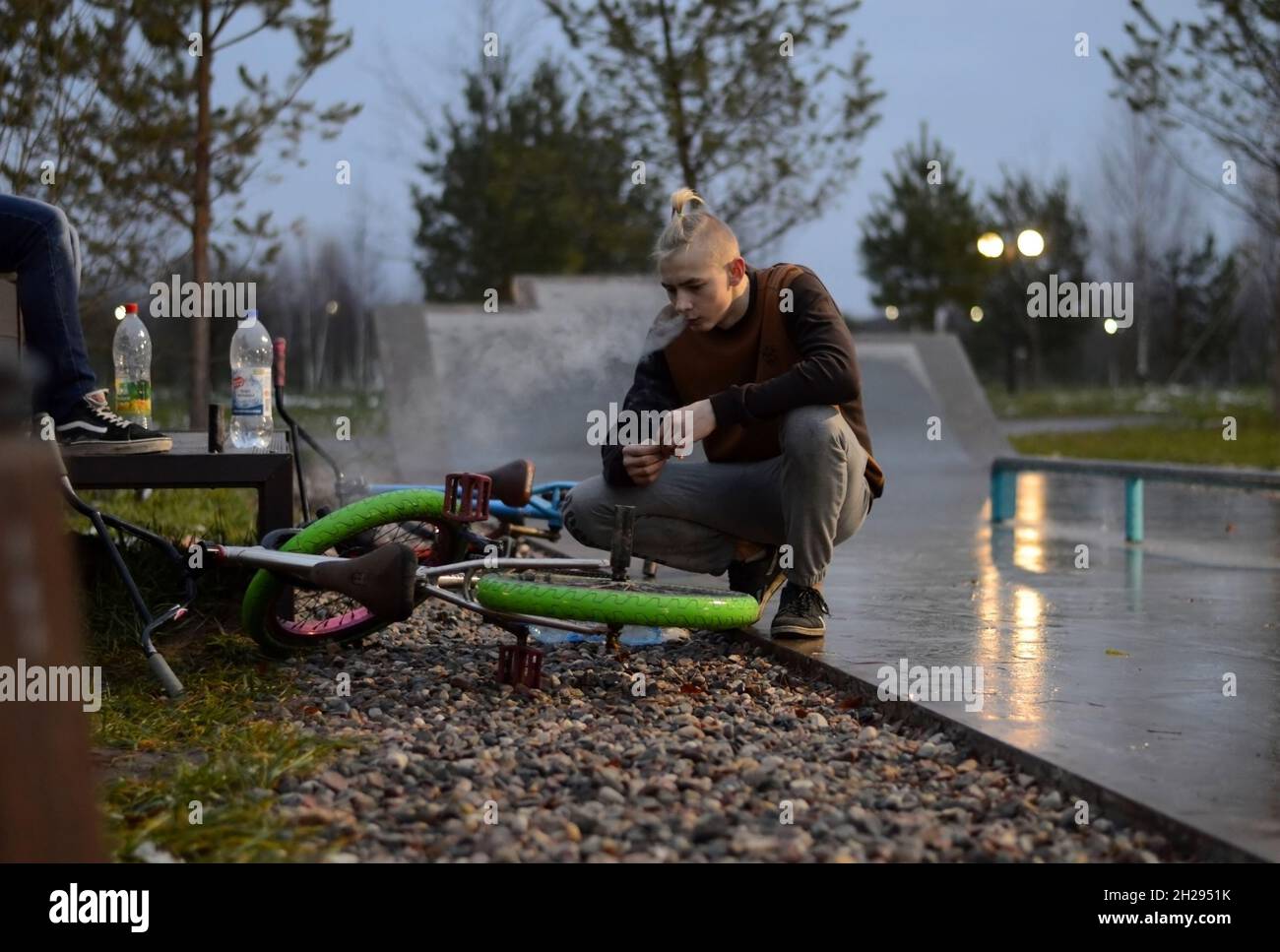 Dobrograd, Vladimir region, Russia. 5 November 2017. Teen who ride on BMX bike resting and smoke ...