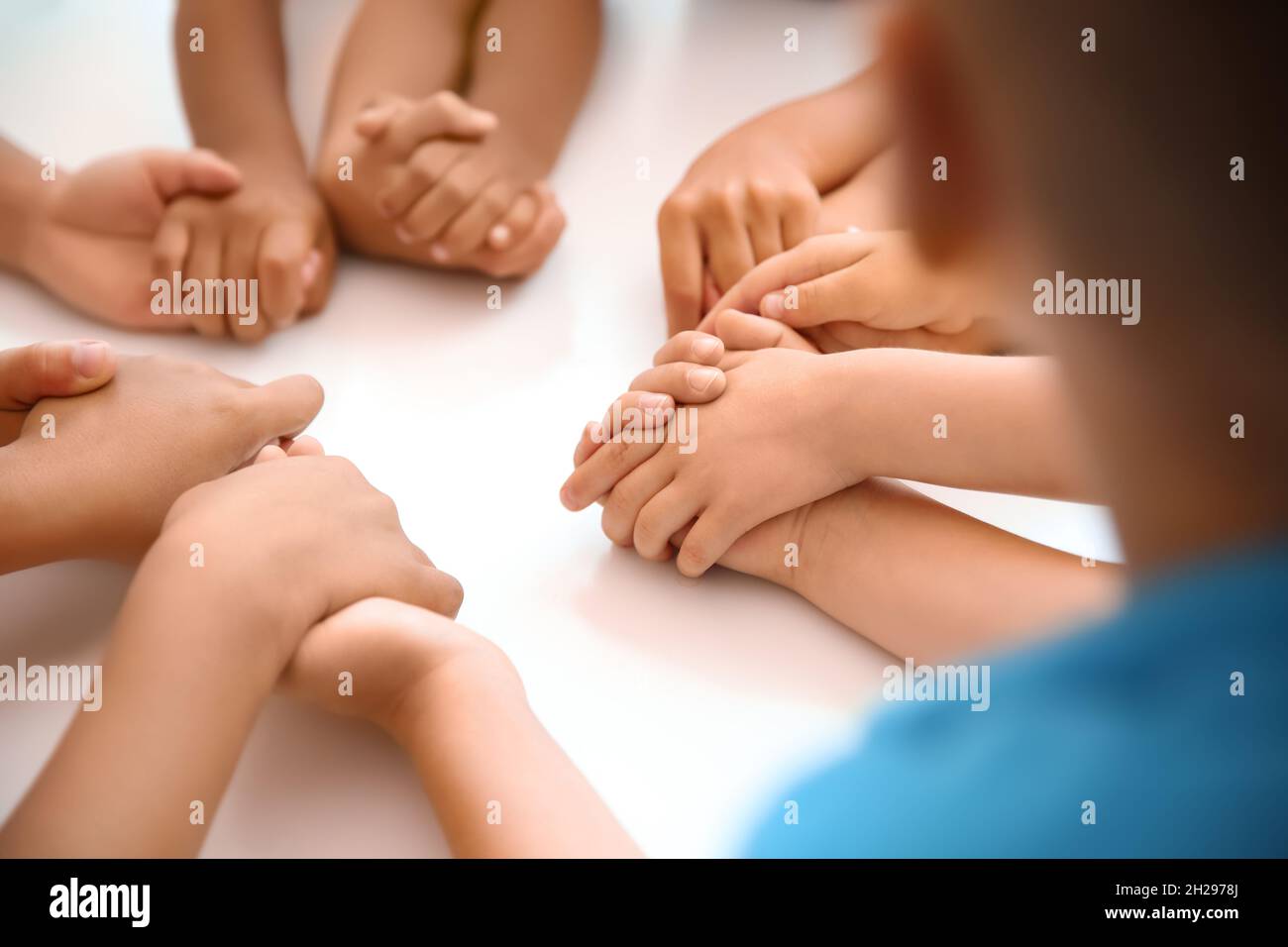 Little children holding hands at table, closeup. Unity concept Stock ...