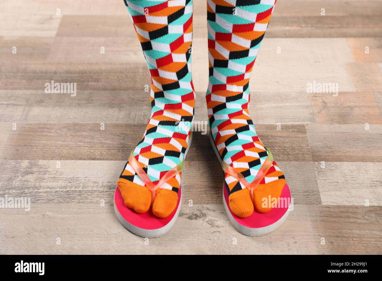 Woman wearing bright socks with flip-flops standing on floor Stock ...