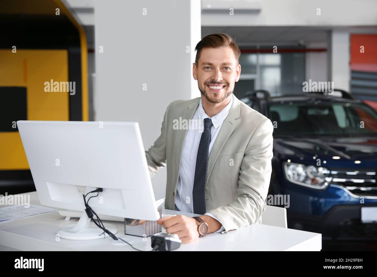 Salesman working in modern car dealership. Buying new auto Stock Photo ...