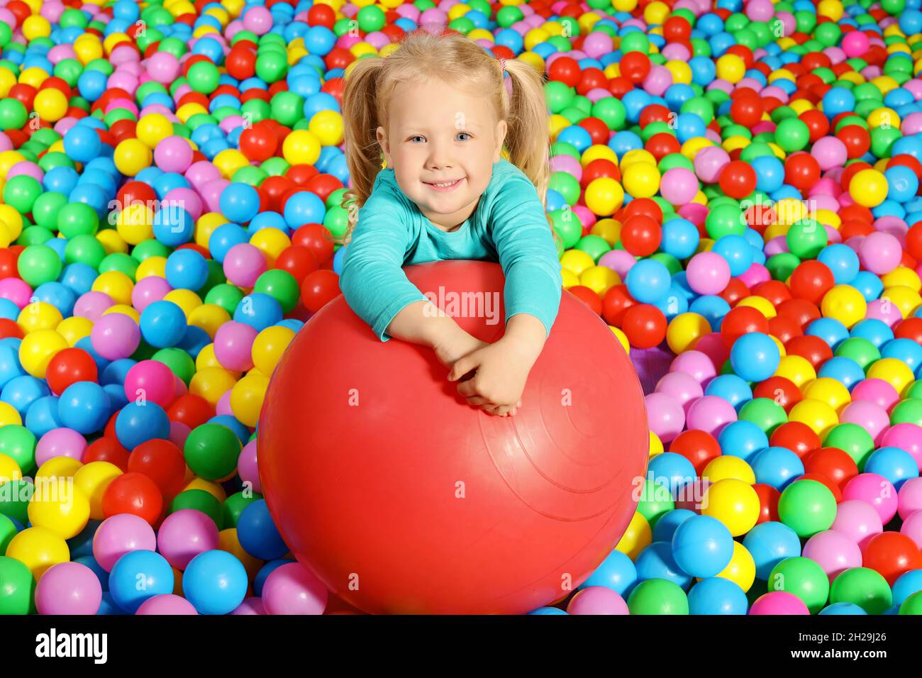 Cute child playing in ball pit indoors Stock Photo - Alamy
