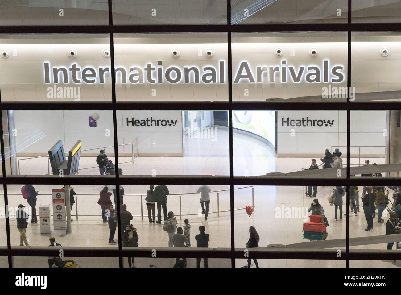 Air passengers arrive at arrival hall at Heathrow International airport ...