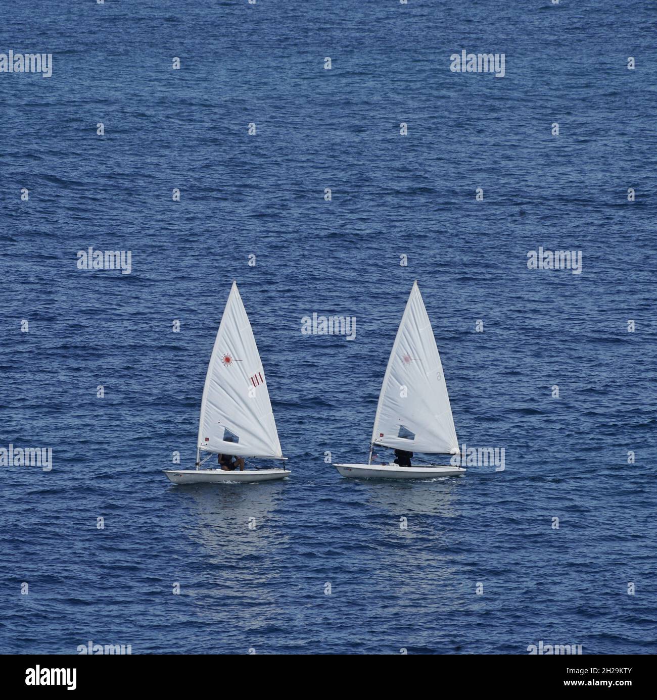 Two sailboats in the wavy sea at a daytime Stock Photo - Alamy