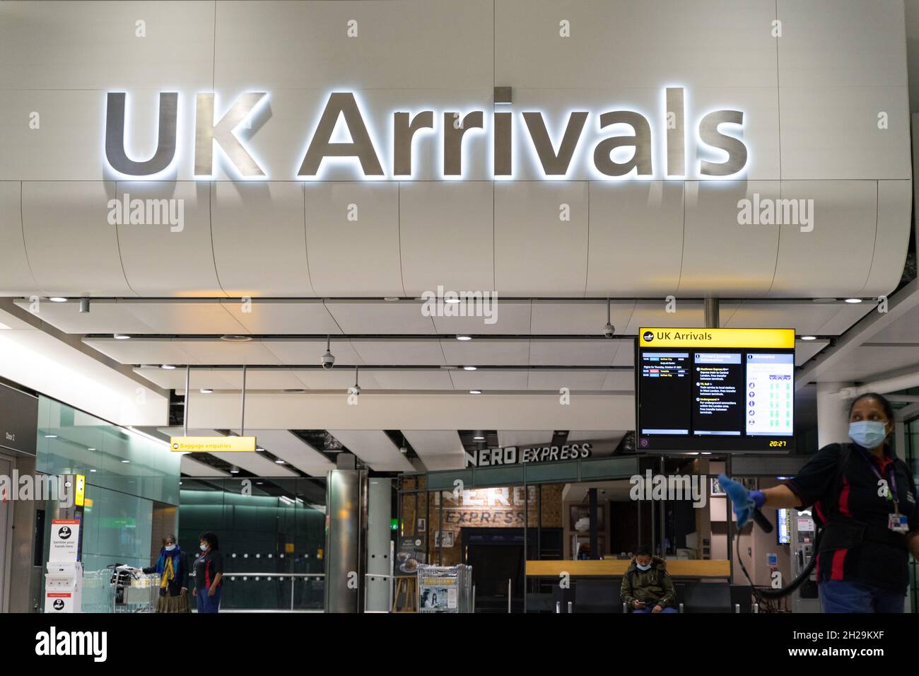 Air passengers arrive at arrival hall at Heathrow International airport ...