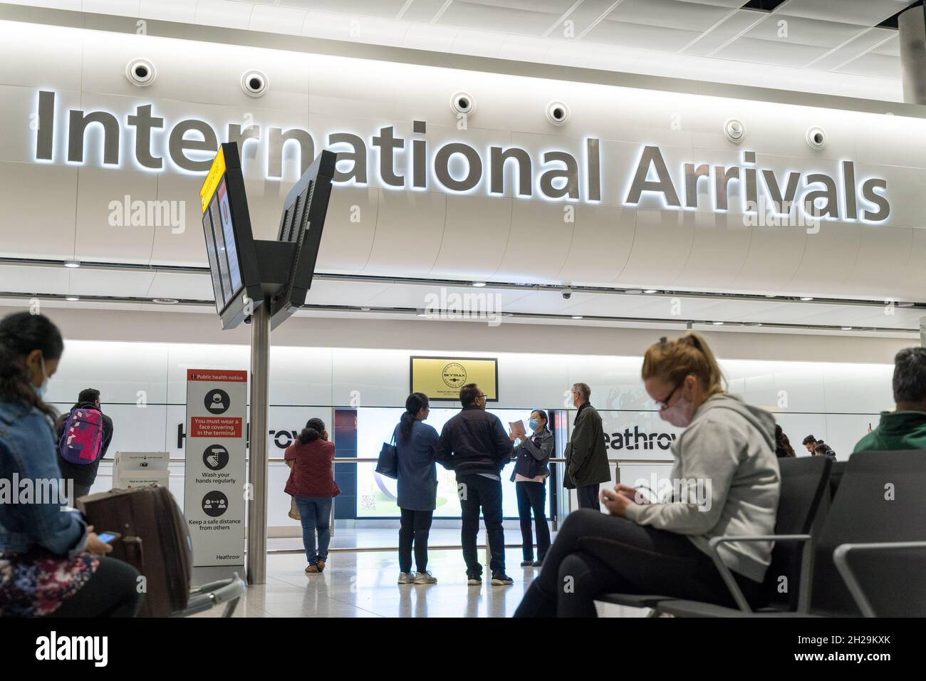 Air passengers arrive at arrival hall at Heathrow International airport ...