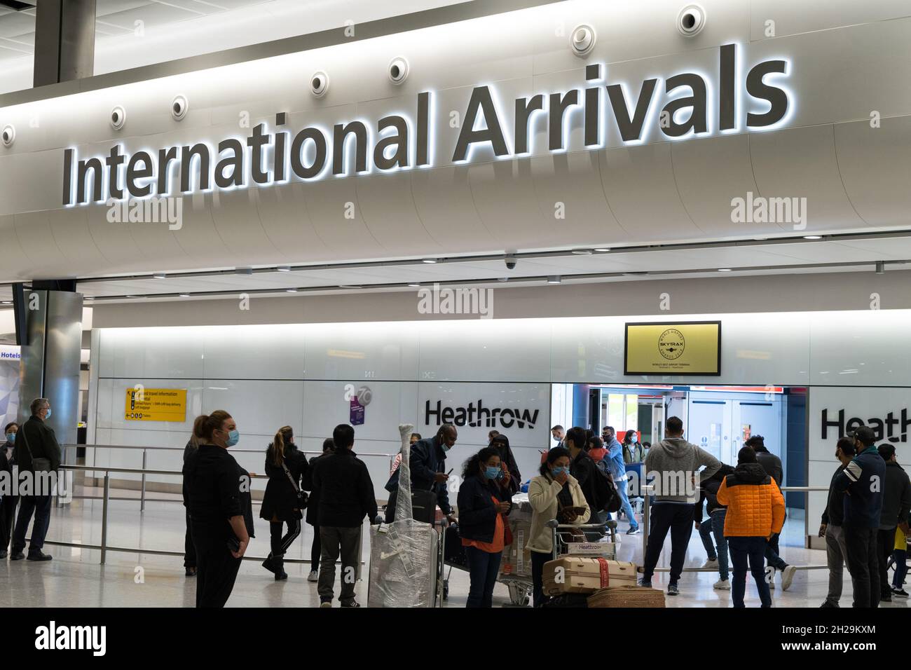 Air passengers arrive at arrival hall at Heathrow International airport ...