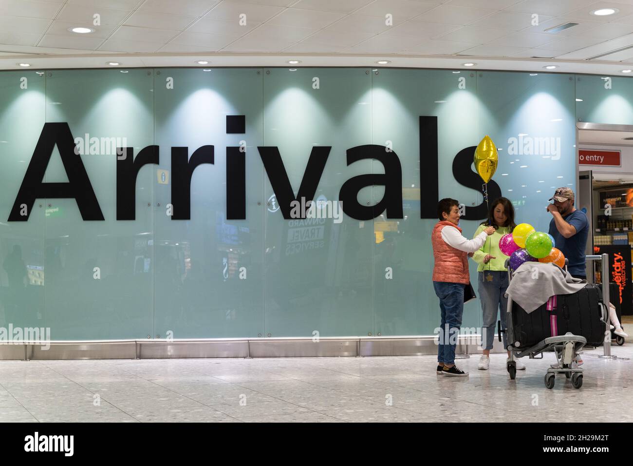 Air passengers arrive at arrival hall at Heathrow International airport ...
