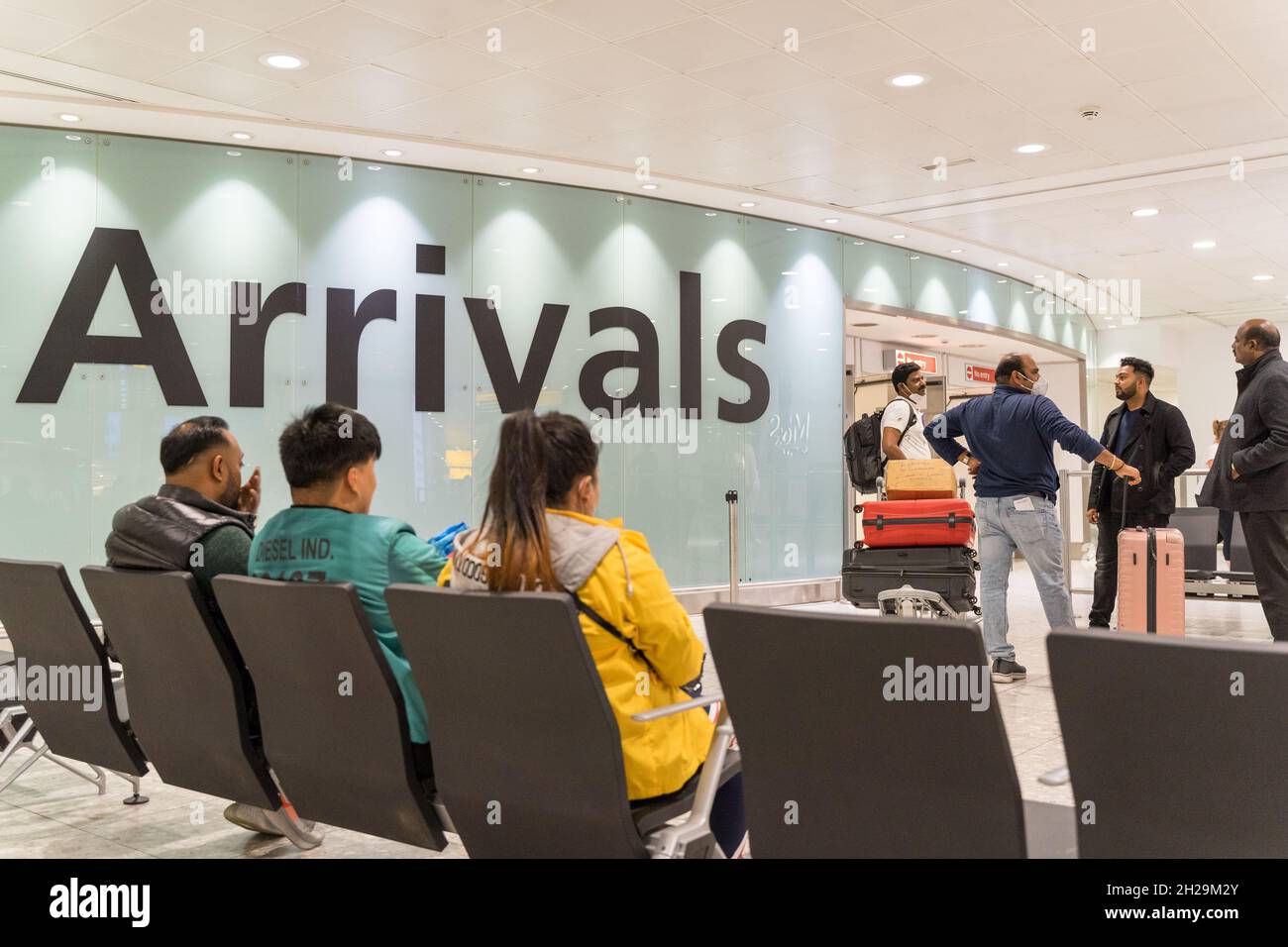 Air passengers arrive at arrival hall at Heathrow International airport ...