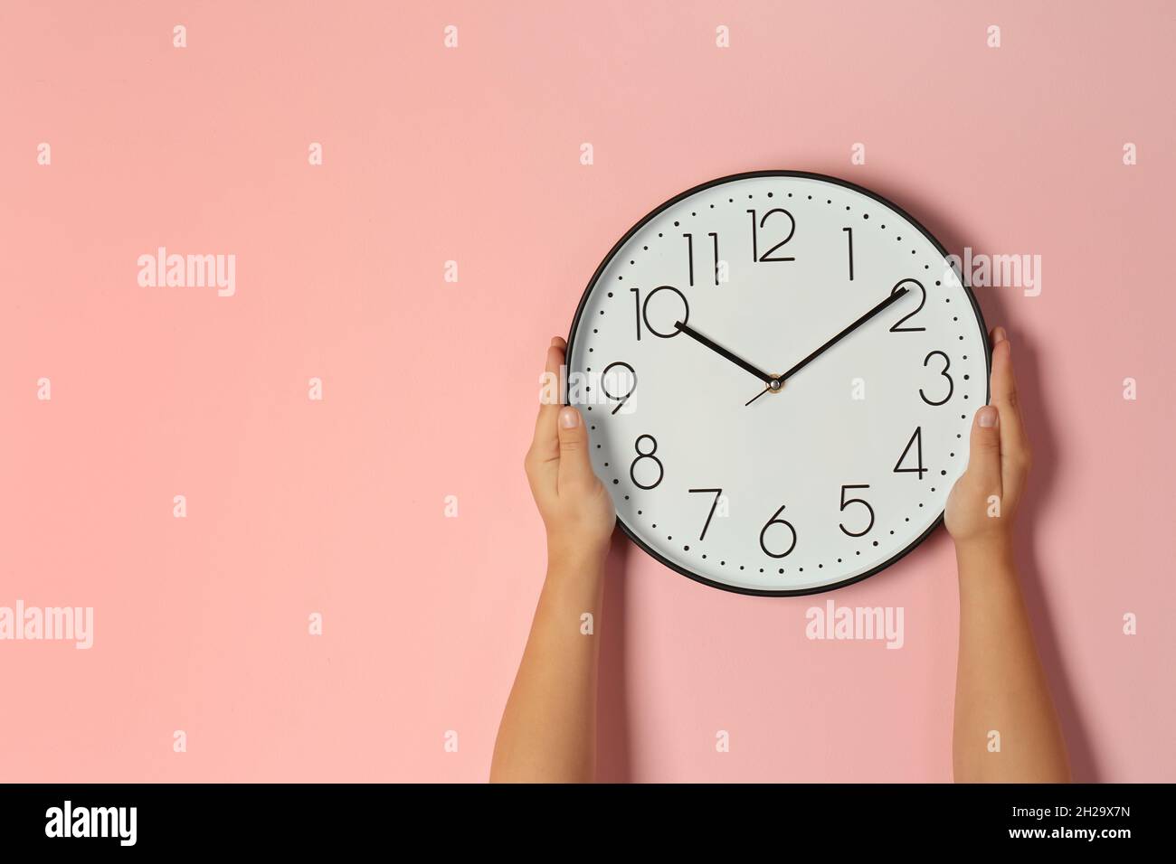 Woman hanging hands of clock hi-res stock photography and images - Alamy
