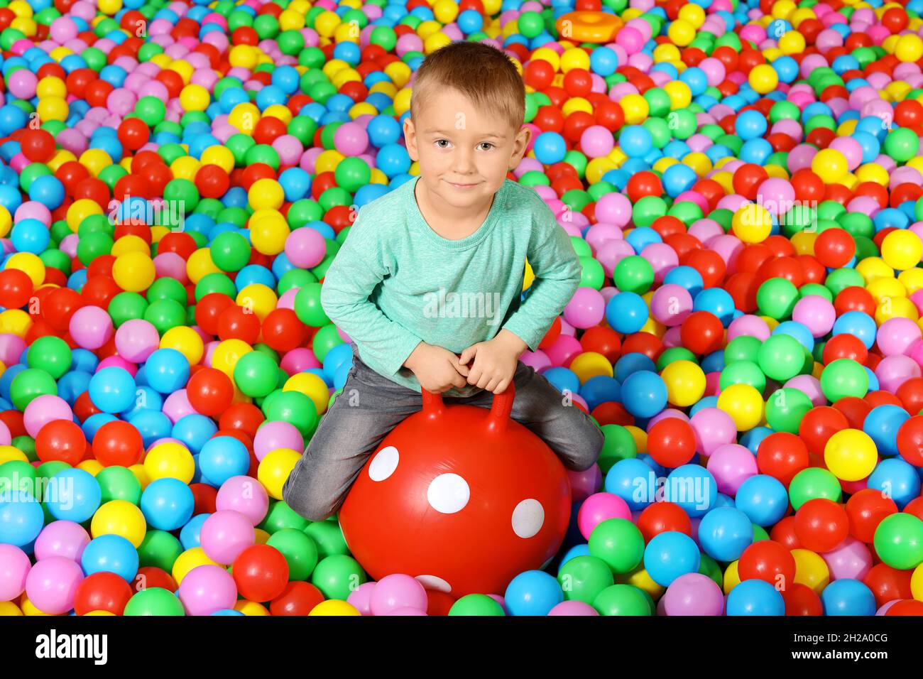 Cute child playing in ball pit indoors Stock Photo - Alamy