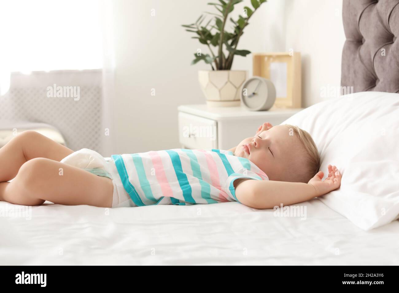 Little child sleeping on bed at home Stock Photo - Alamy