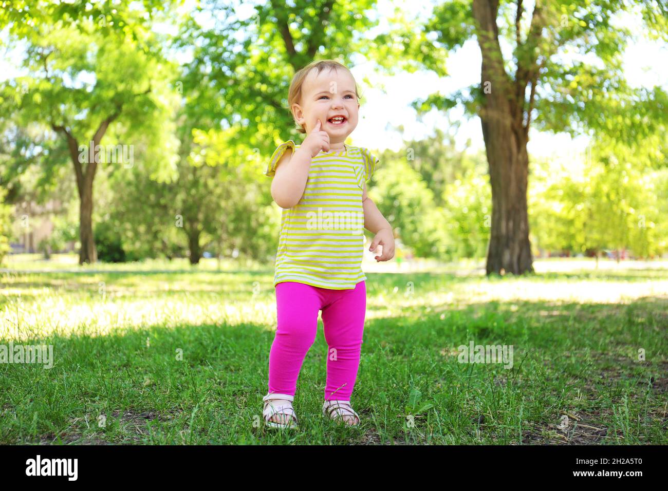 Cute baby girl learning to walk in park on sunny day Stock Photo - Alamy