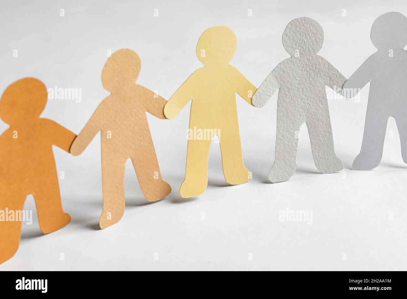 Paper people holding hands on light background. Unity concept Stock ...