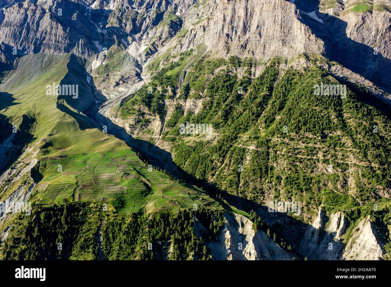 Landscape of green fields and forests on the steep slopes of a ...