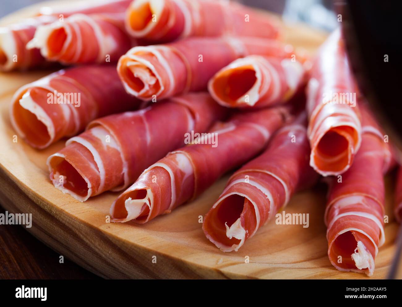 Spanish tasty meal rolls of prosciutto di parma at wooden desk Stock ...