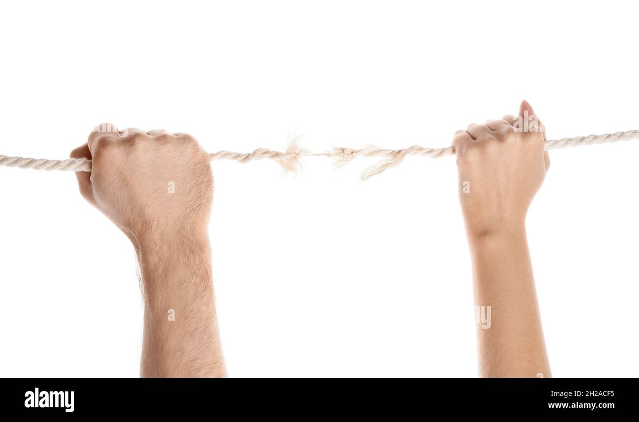 Man and woman pulling frayed rope at breaking point on white background ...