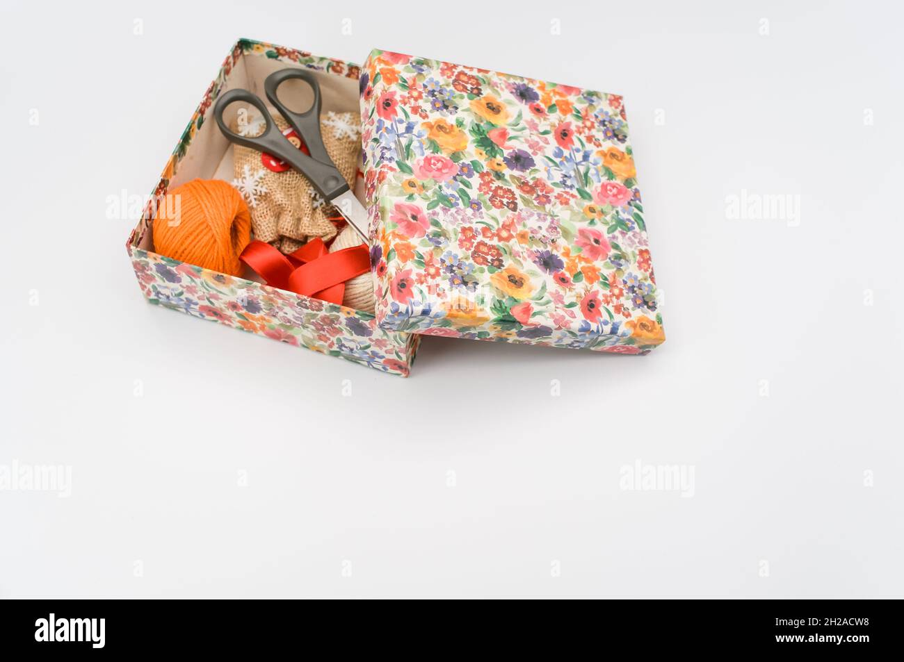 paperboard box with floral decorations and stationery on a white ...