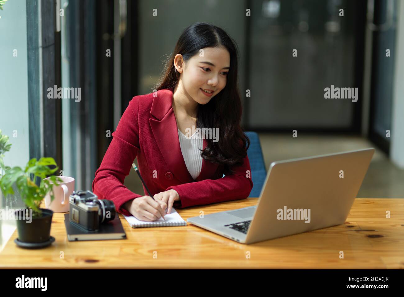 Elegant asian businesswoman working in the office, taking notes while ...