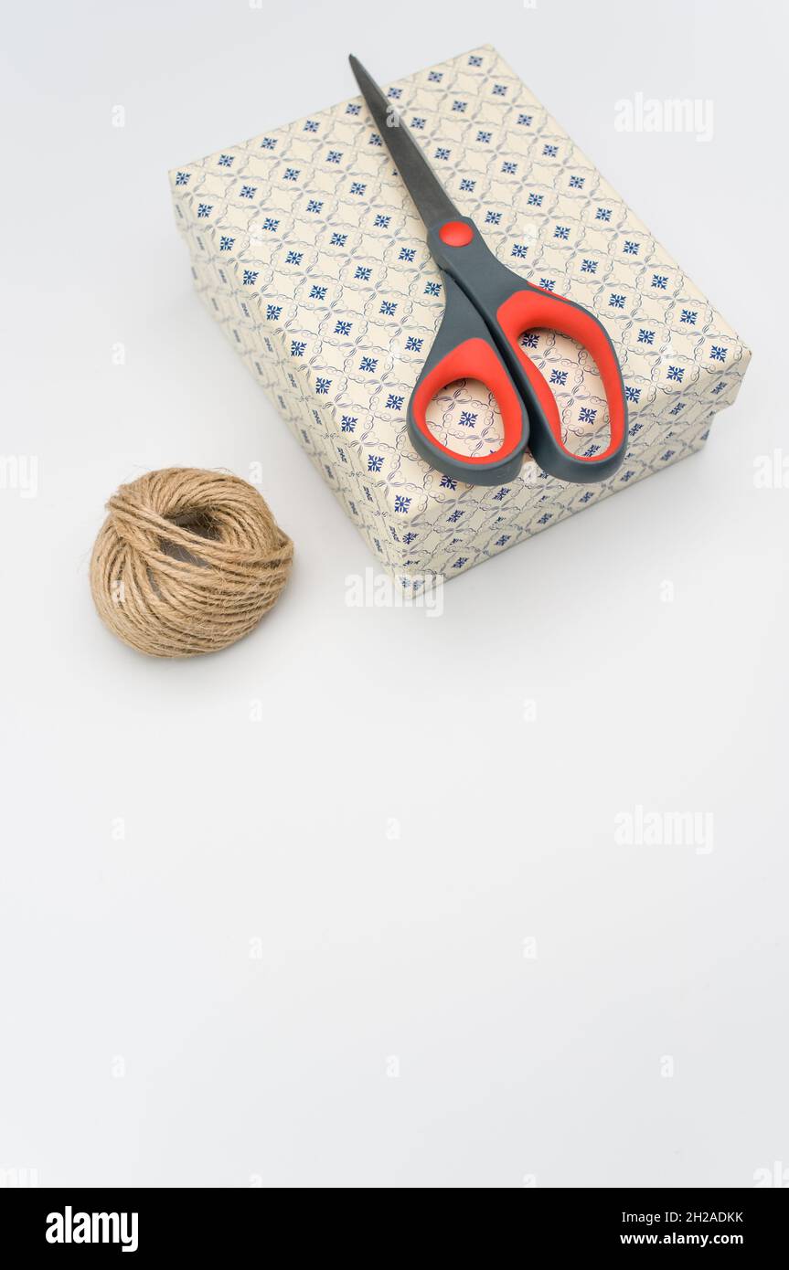 decorated paperboard box with scissors and decorative yarn on a white ...