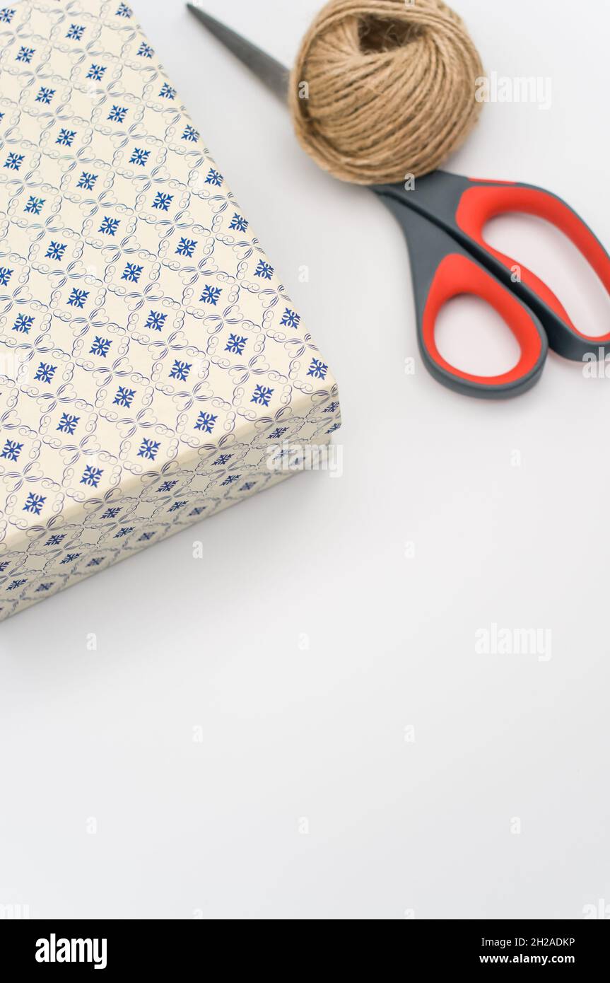 decorated paperboard box with scissors and decorative yarn on a white ...
