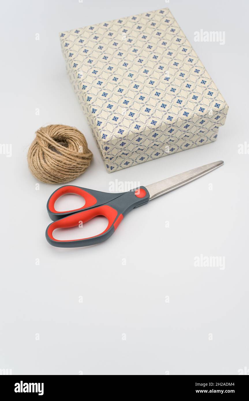 decorated paperboard box with scissors and decorative yarn on a white ...