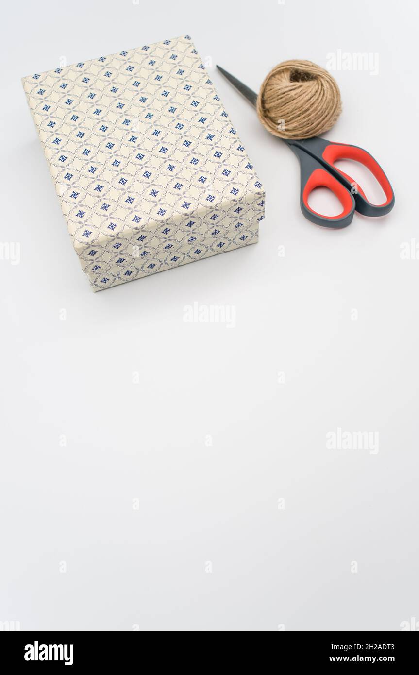 decorated paperboard box with scissors and decorative yarn on a white ...