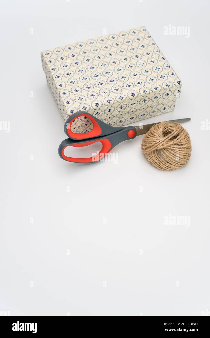 decorated paperboard box with scissors and decorative yarn on a white ...