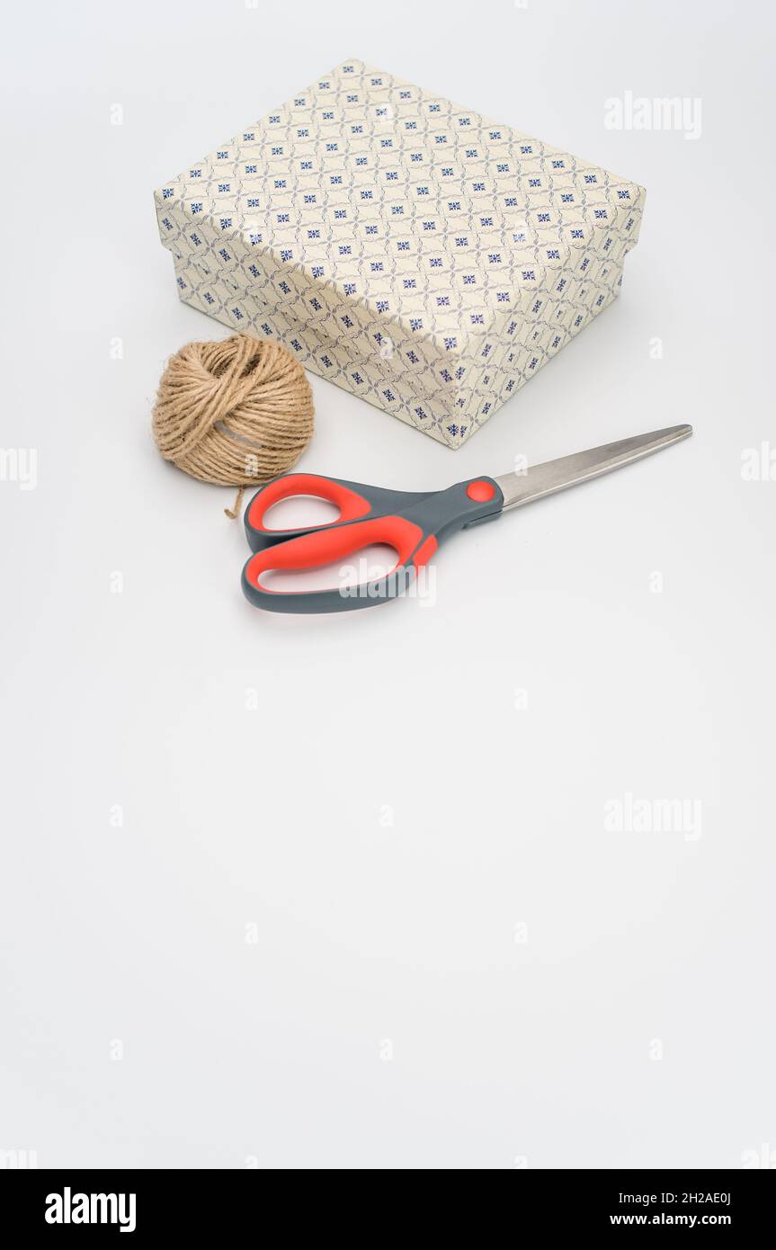 decorated paperboard box with scissors and decorative yarn on a white ...