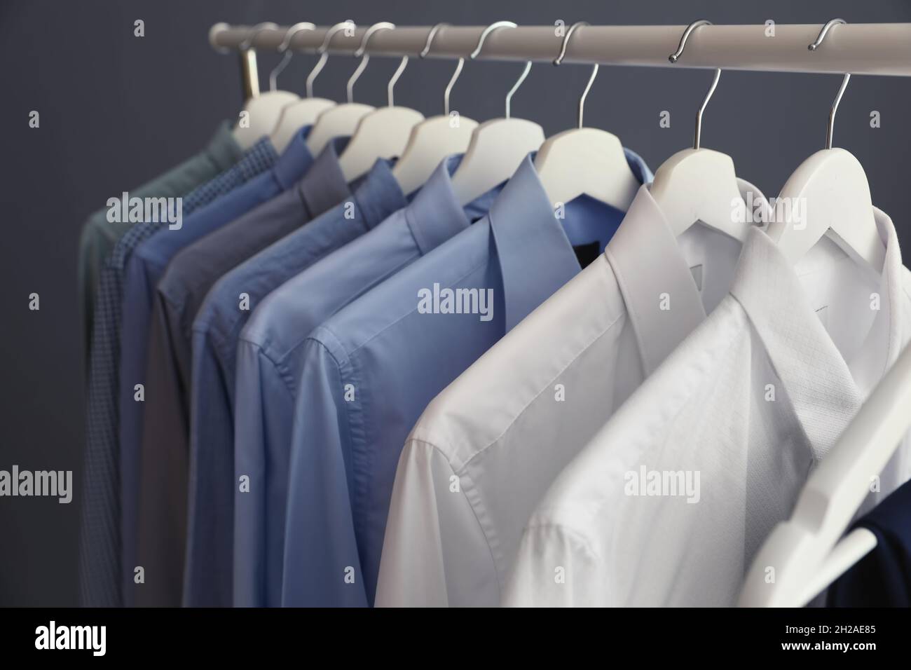 Wardrobe rack with men's clothes on grey background, closeup Stock ...