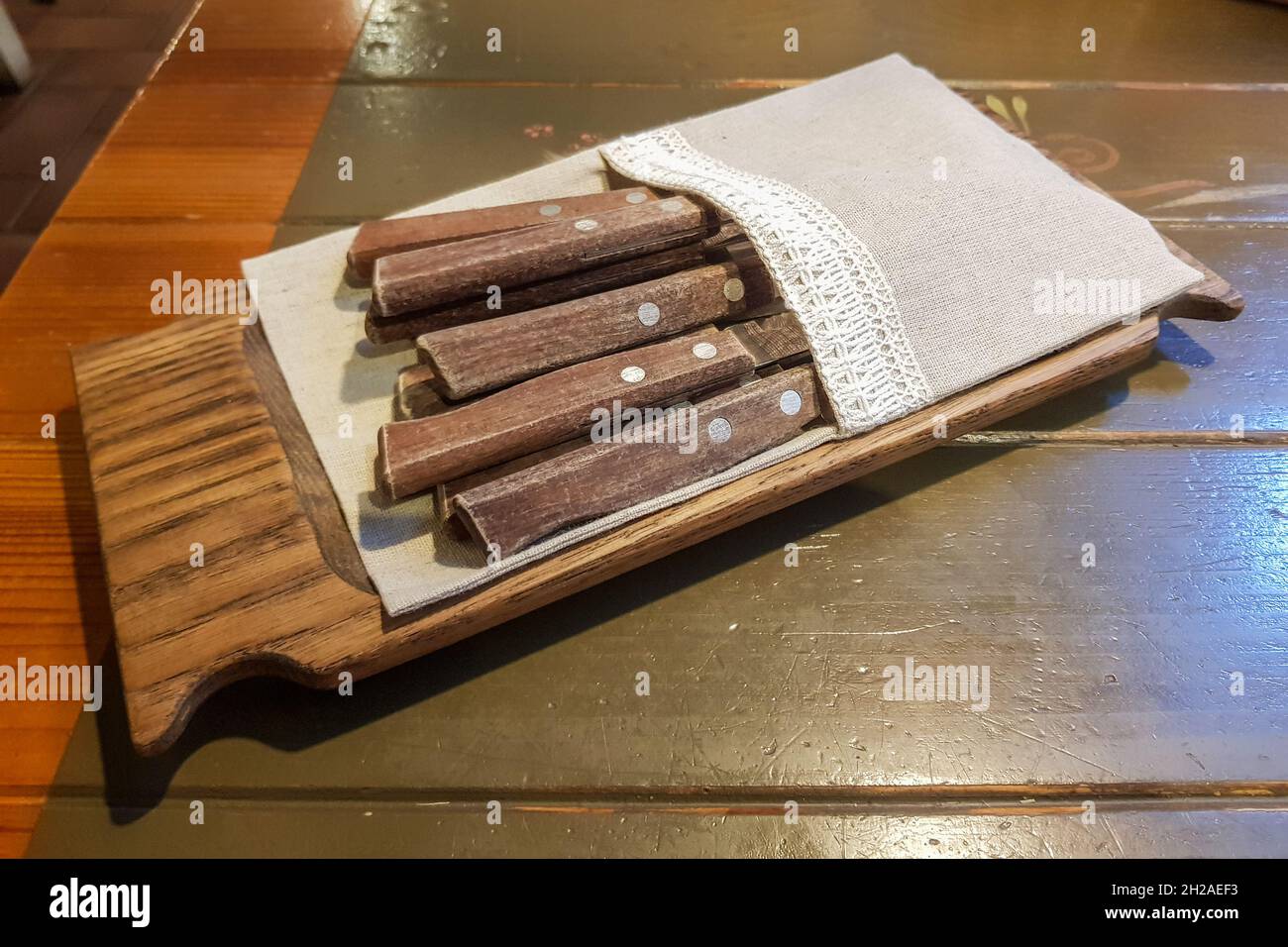 forks and knives with wooden handles are on the table in the restaurant ...