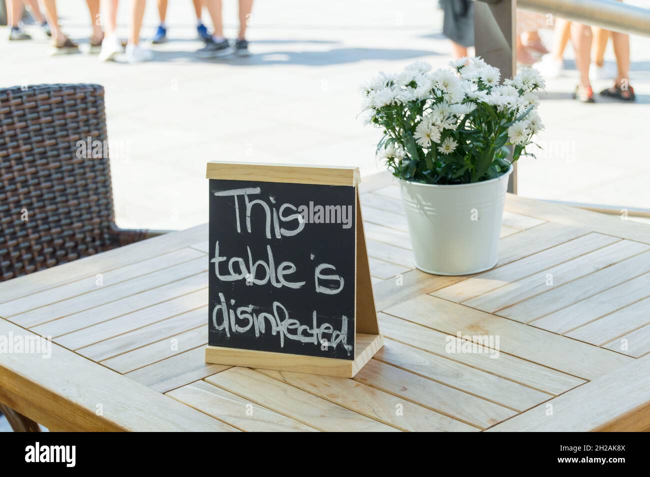 Wooden blackboard as table sign on a sanitized table in a restaurant ...