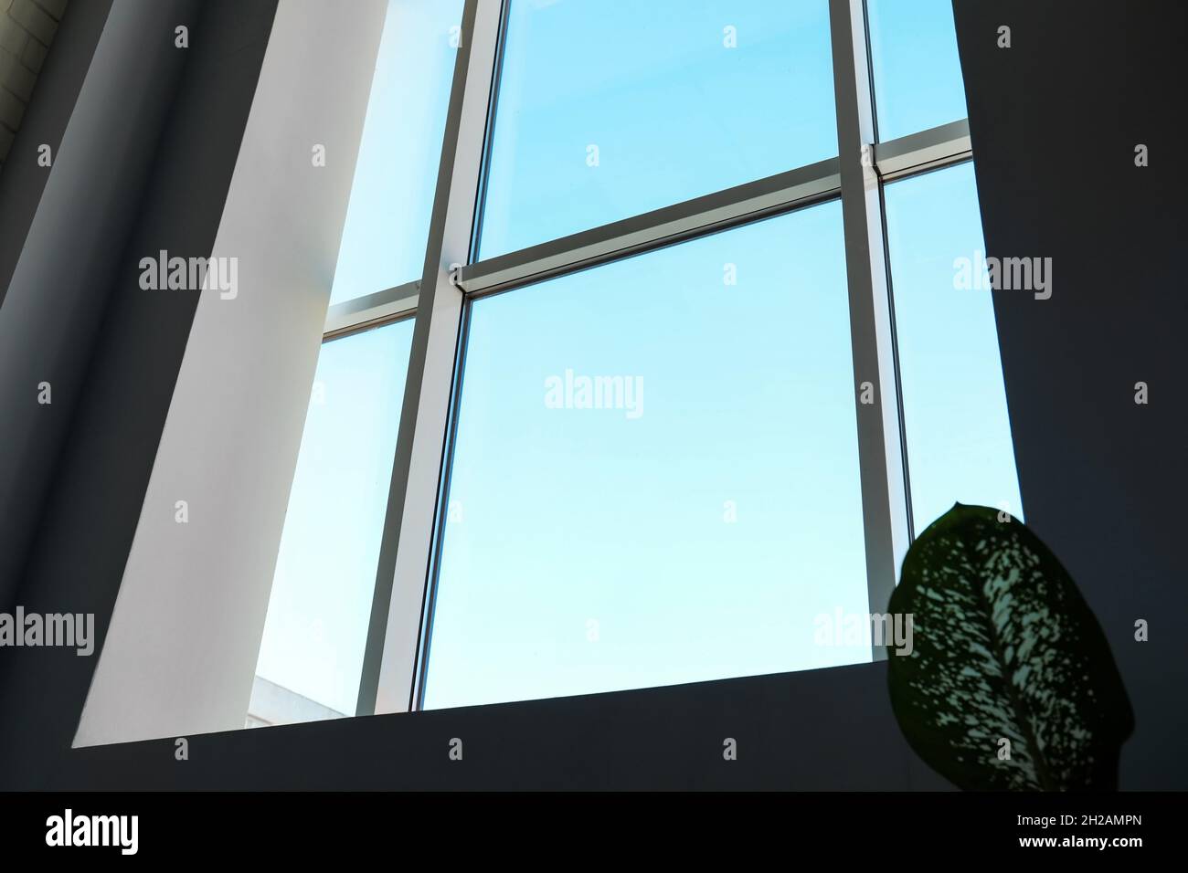 View of blue sky through large modern window indoors Stock Photo - Alamy
