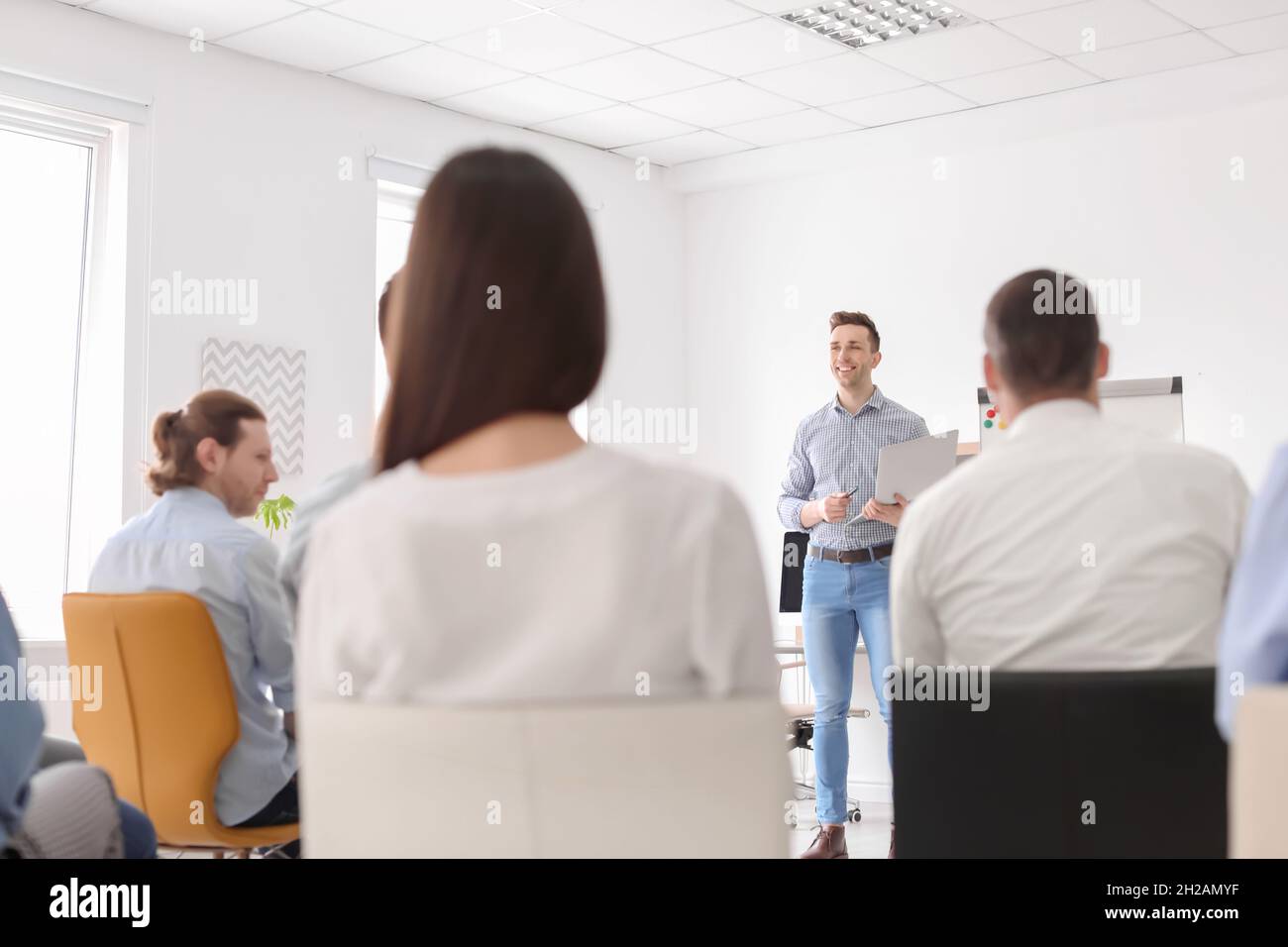 Male business trainer giving lecture in office Stock Photo - Alamy