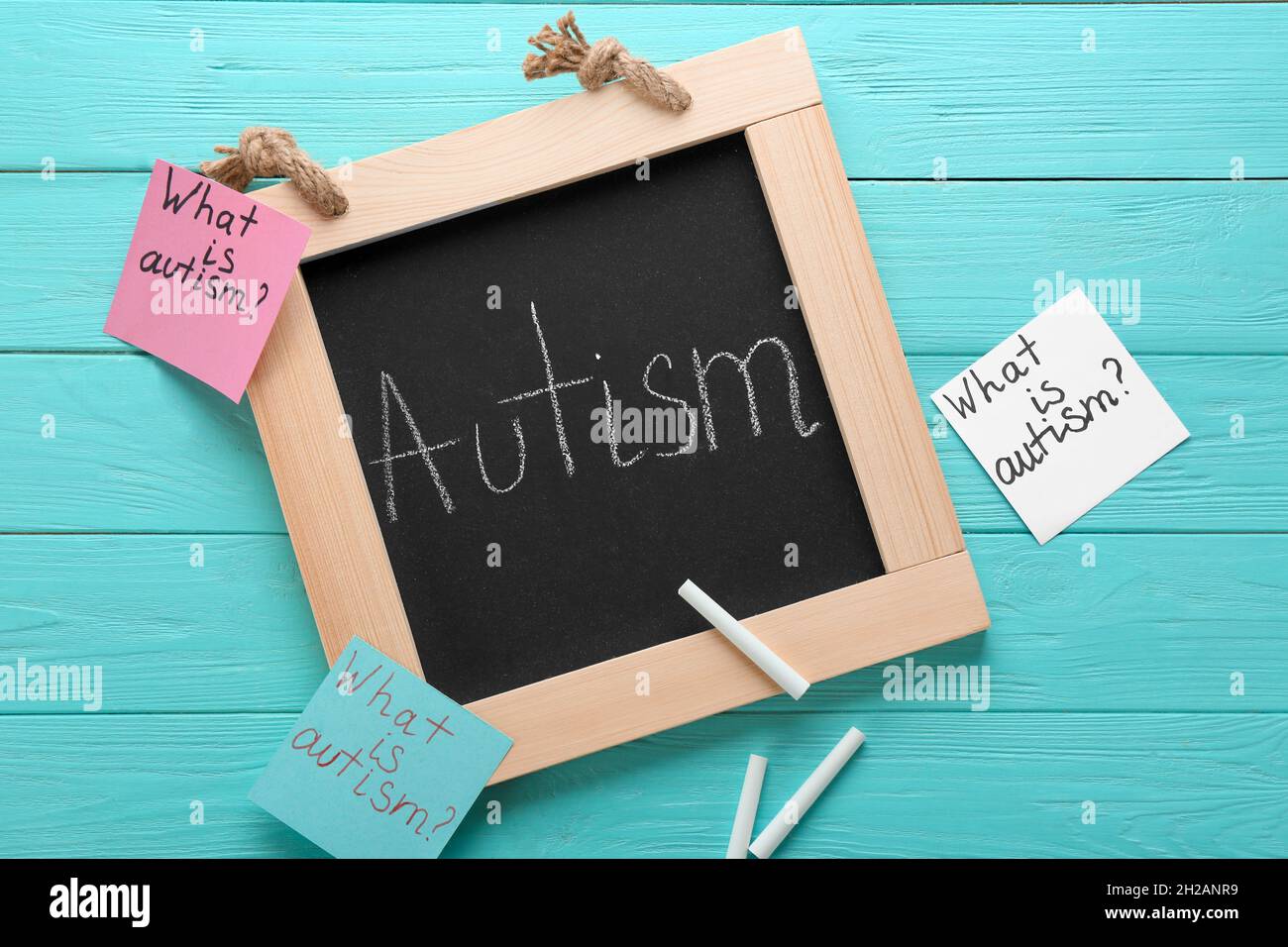 Chalkboard with word "Autism" and paper notes on wooden background ...