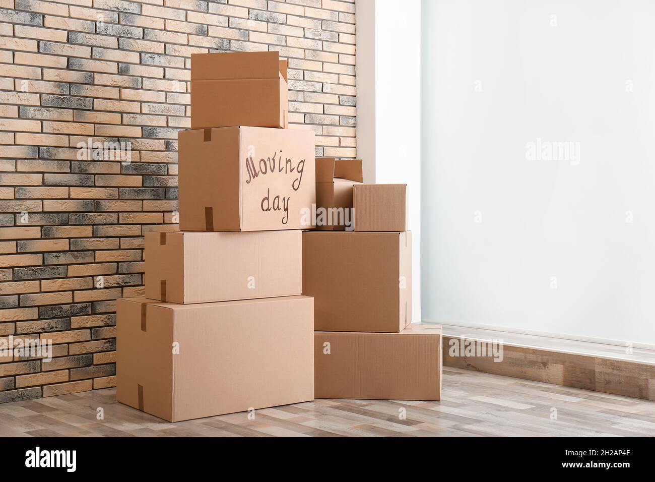 Pile of moving boxes in empty room Stock Photo - Alamy