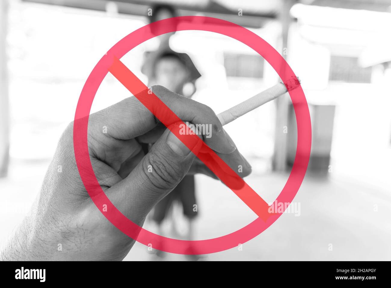 No smoking sign on cigarette in hand with burred of children background ...