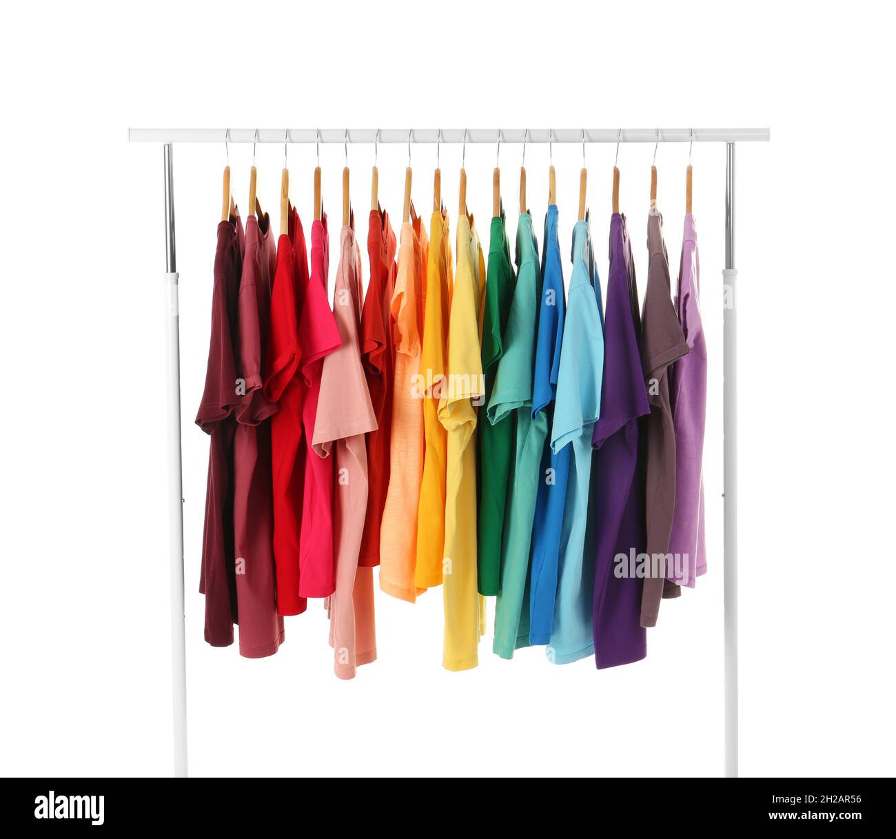 Many t-shirts hanging in order of rainbow colors on white background ...