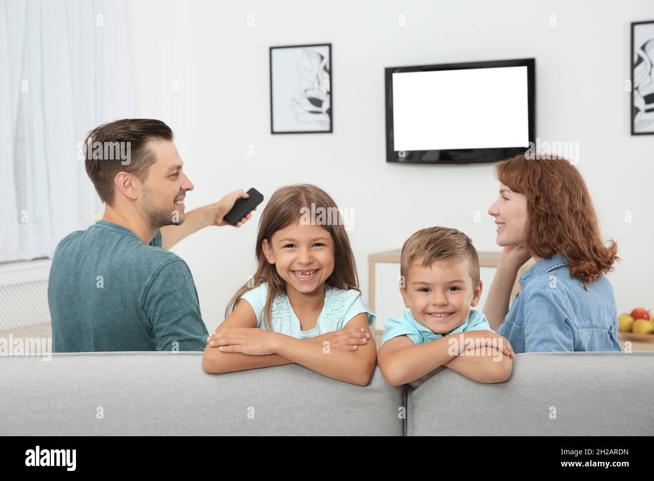 Family watching TV in room at home Stock Photo - Alamy