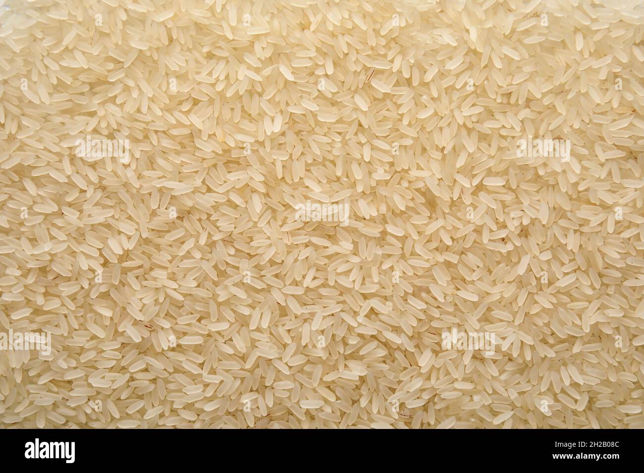 Pile of uncooked rice as background, top view Stock Photo - Alamy