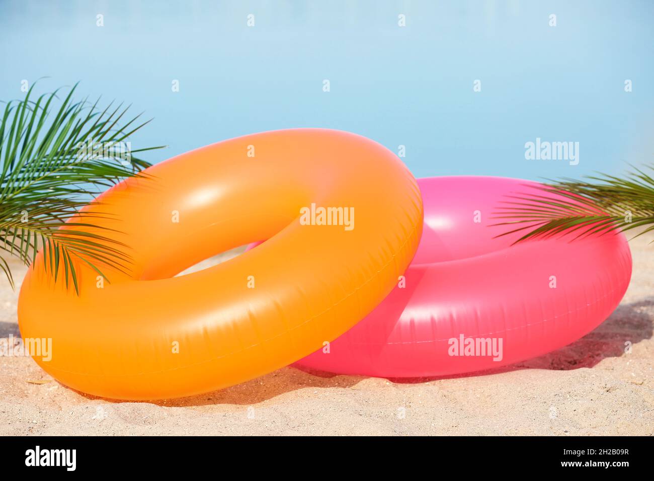 Colorful inflatable rings on sand. Beach object Stock Photo - Alamy