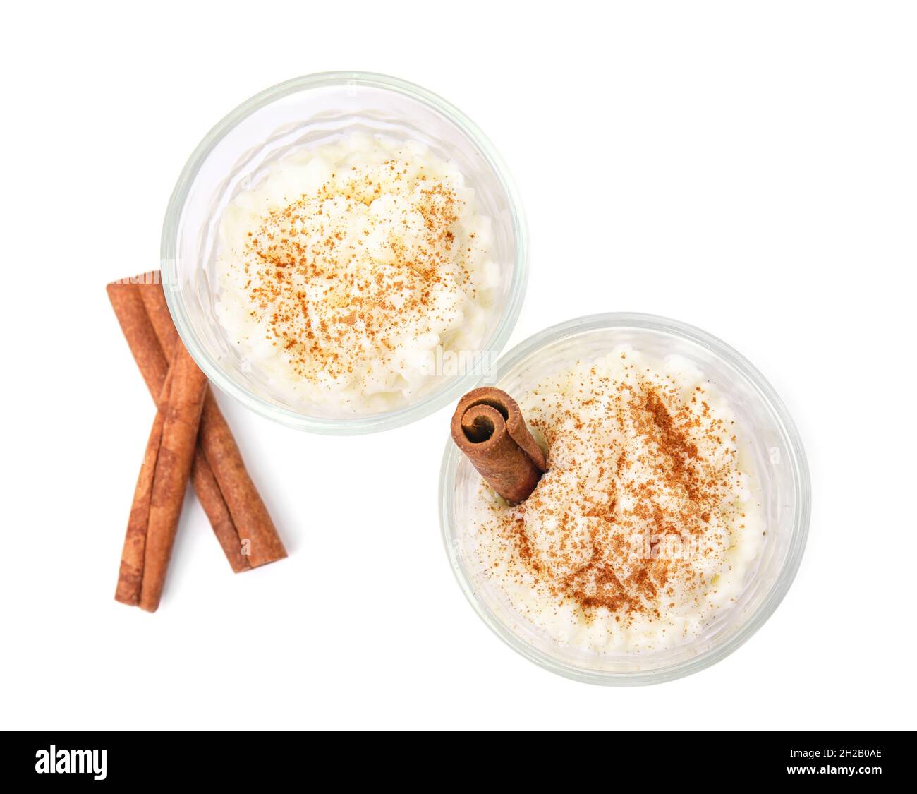 Creamy rice pudding with cinnamon in glasses on white background, top ...