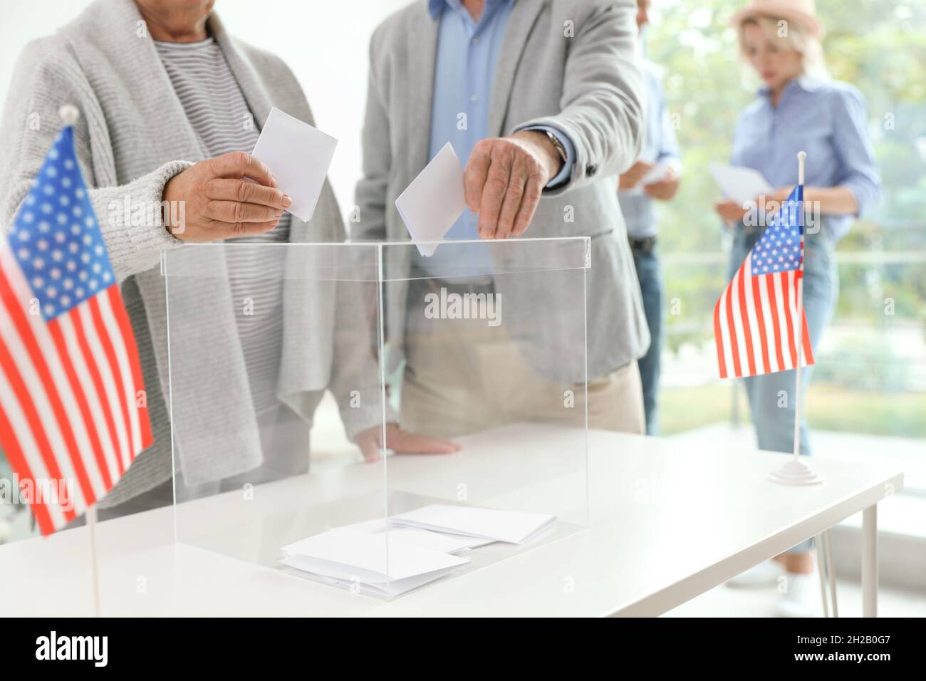 Elderly people putting ballot papers into box at polling station Stock ...