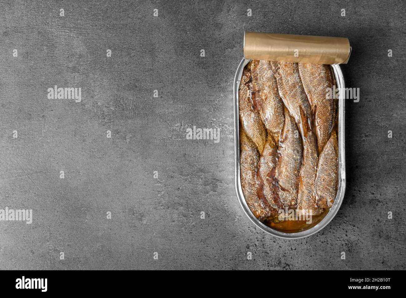 Tin can with conserved fish on grey background, top view Stock Photo ...