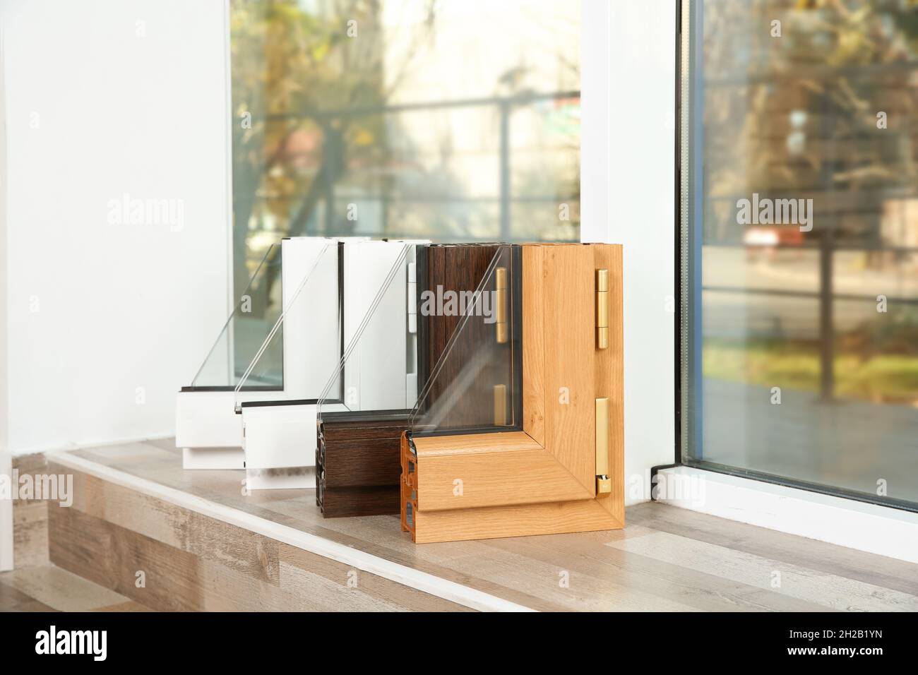Samples of modern window profiles on sill indoors, space for text ...